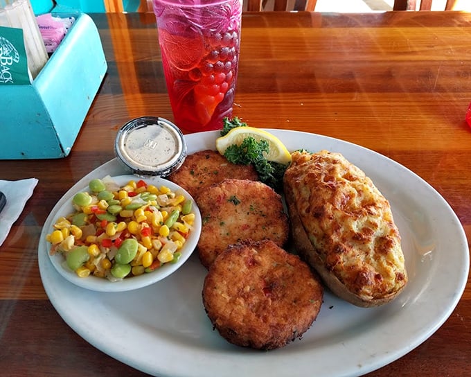 Golden-brown crab cakes with a side of summer vegetables – proof that sometimes the simplest preparations let great ingredients sing their own delicious song.