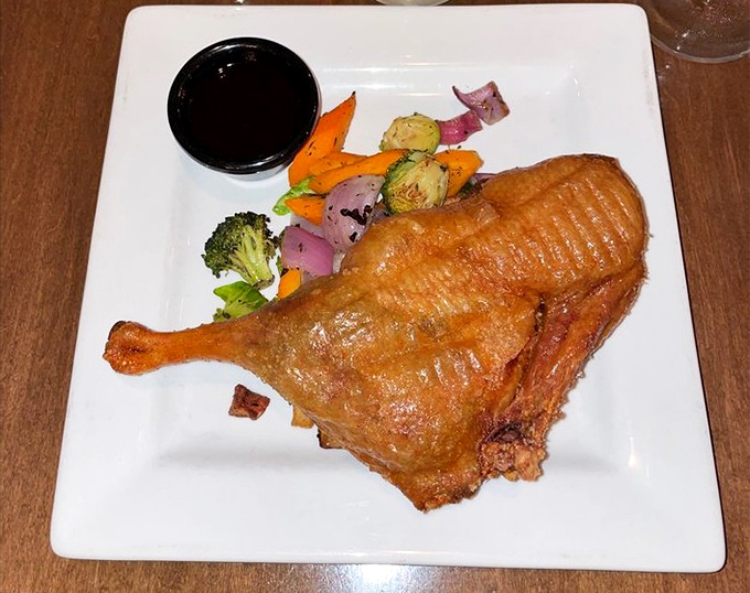 Crispy duck that would make French chefs weep with joy, served with colorful roasted vegetables that aren't just playing supporting roles.