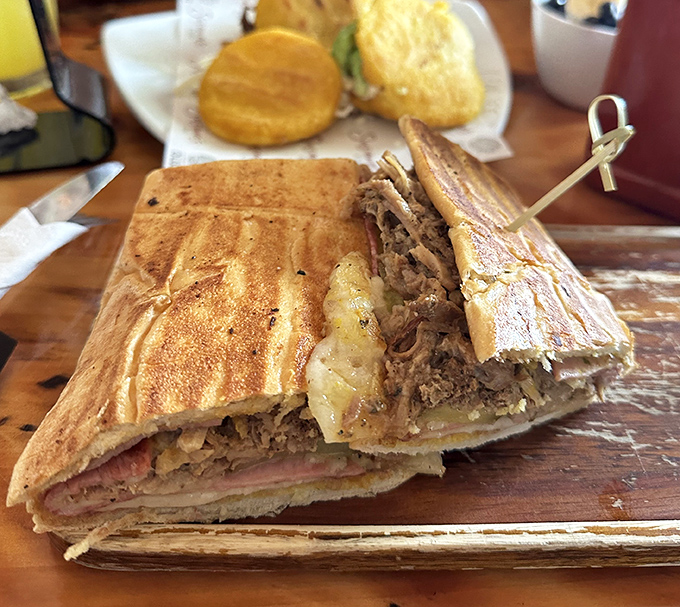 The Cuban sandwich arrives pressed to perfection, layers of ham and roasted pork playing hide-and-seek with pickles and melted cheese between crispy bread.