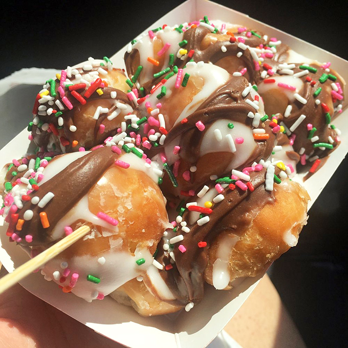 Donut holes elevated to star status with chocolate dips and rainbow sprinkles&mdash;proof that good things come in small packages.