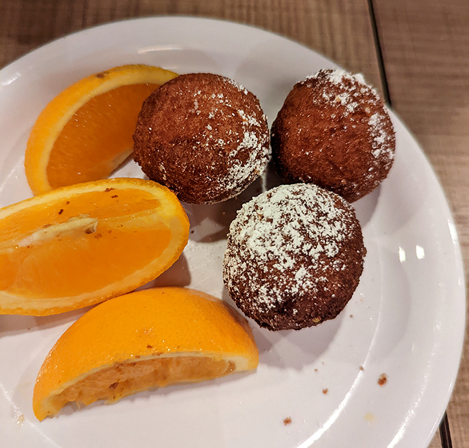 These donut holes aren't just treats&mdash;they're edible welcome mats, dusted with powdered sugar and served with orange slices for that vitamin C alibi.