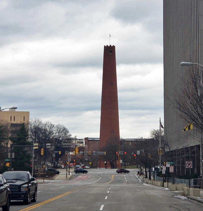 The Shot Tower stands defiant among modern buildings, like that one history buff at a tech conference who refuses to upgrade their flip phone.