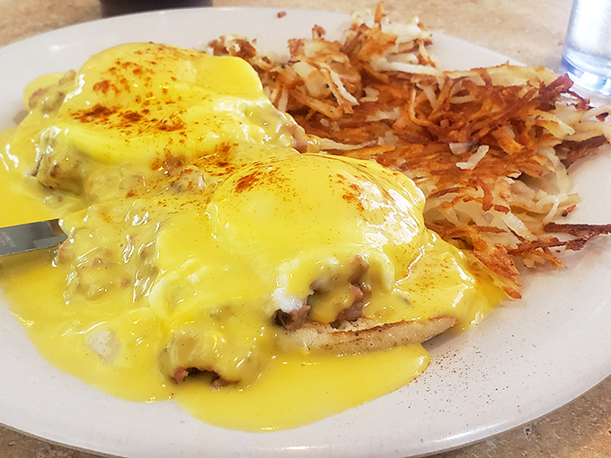 Eggs Benedict with a golden hollandaise cascade that would make Niagara Falls jealous, paired with hash browns crisped to perfection.