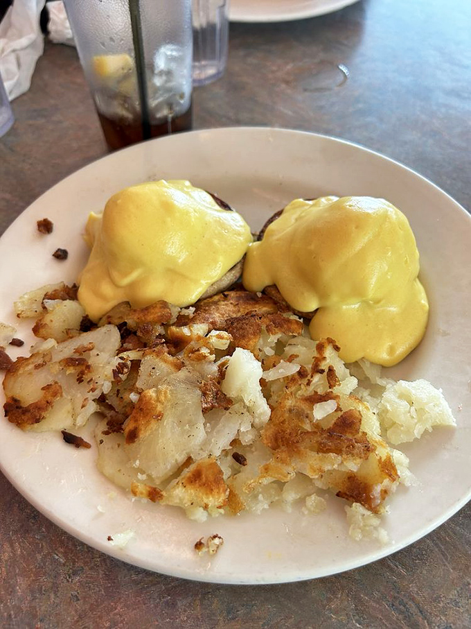 Eggs Benedict done right&mdash;golden hollandaise cascading over perfectly poached eggs. The crispy home fries are playing no supporting role here.
