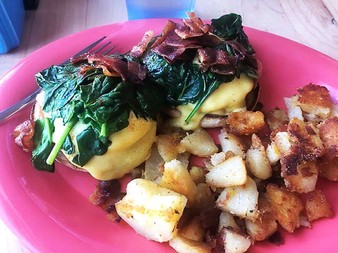 Eggs Benedict elevated to art form, where hollandaise flows like liquid sunshine over perfectly poached perfection.