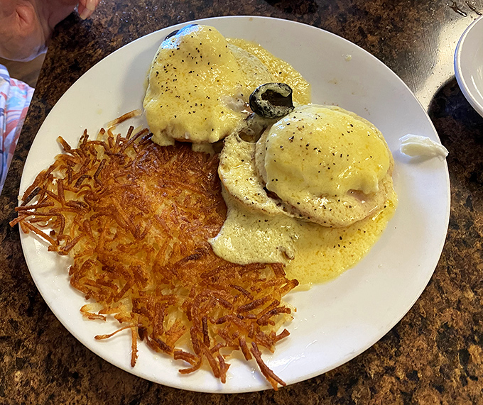 Eggs Benedict that could make a Frenchman weep with joy. Those crispy hash browns aren't playing a supporting role—they're co-starring in this breakfast drama.