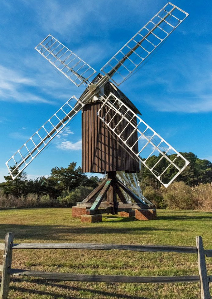 Against a brilliant blue sky, the windmill's skeletal sails create geometric patterns that would make any Instagram filter jealous. 