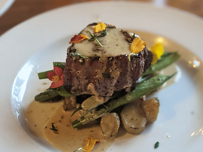 Filet mignon that's dressed for success with a velvety sauce, edible flowers, and vegetables that know their supporting role in this meaty masterpiece.