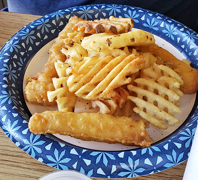 Crispy fish and waffle fries on a blue-patterned plate&mdash;proof that while chicken rules the roost, the supporting cast deserves applause too.