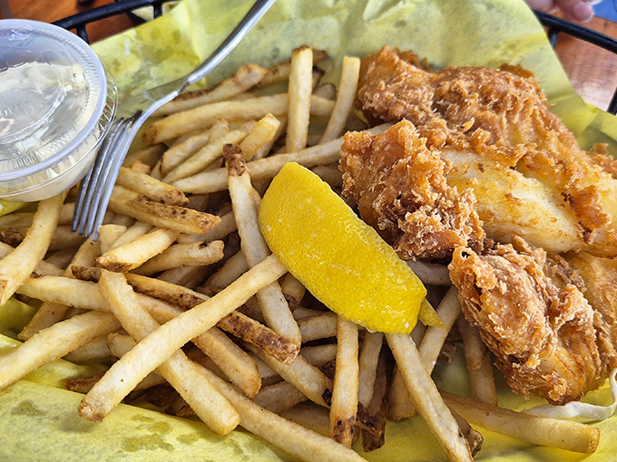 Fish and chips done right – golden, crispy batter protecting flaky white fish, with fries standing by for the inevitable "just one more bite" syndrome.