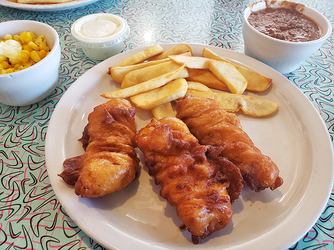 Golden-battered fish that shatters with each bite, paired with fries that somehow maintain their crispness even as you contemplate a second piece.