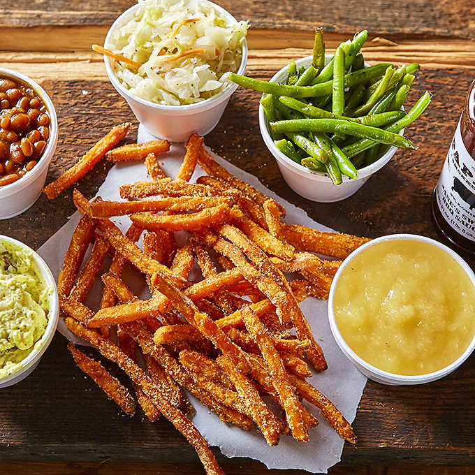 Sweet potato fries dusted with spices, surrounded by a United Nations of sides. This isn't a meal; it's a diplomatic summit of flavors.