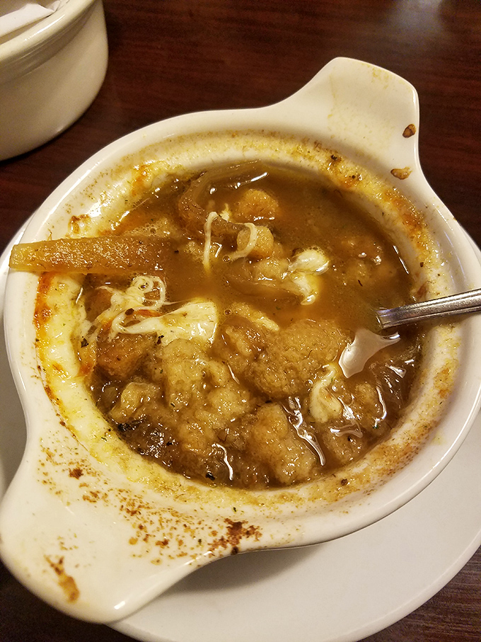 The legendary French onion soup&mdash;where caramelized onions swim in rich broth beneath a canopy of melted cheese that stretches with each spoonful like nature intended.