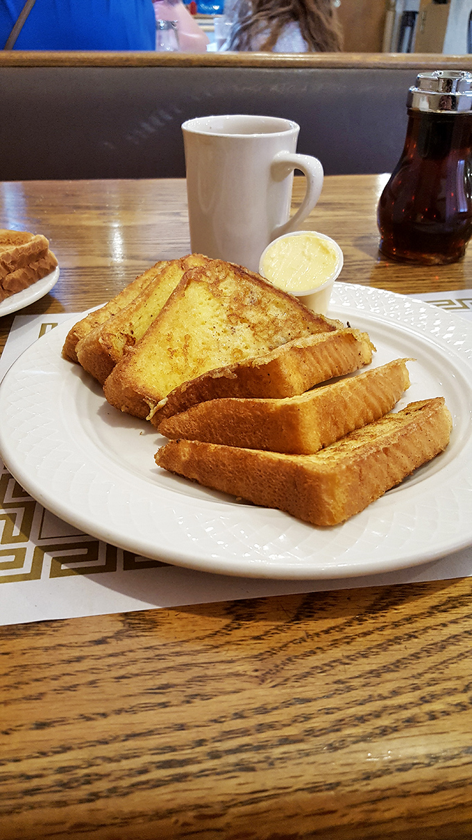 French toast done right: perfectly golden, slightly crisp edges, and soft centers that eagerly soak up maple syrup like a sponge at a spill.