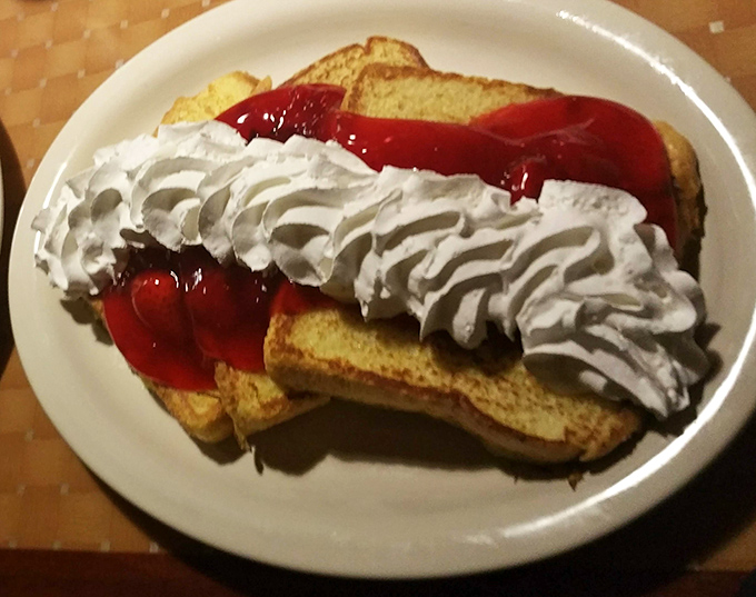 French toast that's dressed for success with strawberry topping and enough whipped cream to make your cardiologist wince. Worth it.