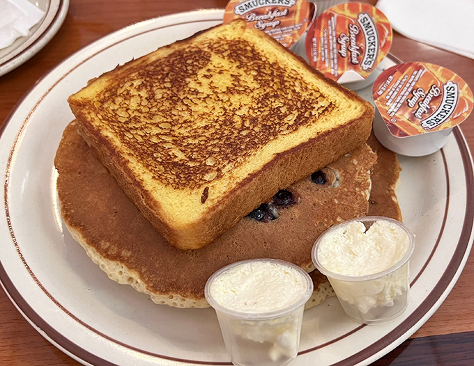 Breakfast identity crisis in the best possible way&mdash;golden French toast atop blueberry pancakes. Like getting the window and aisle seat simultaneously.