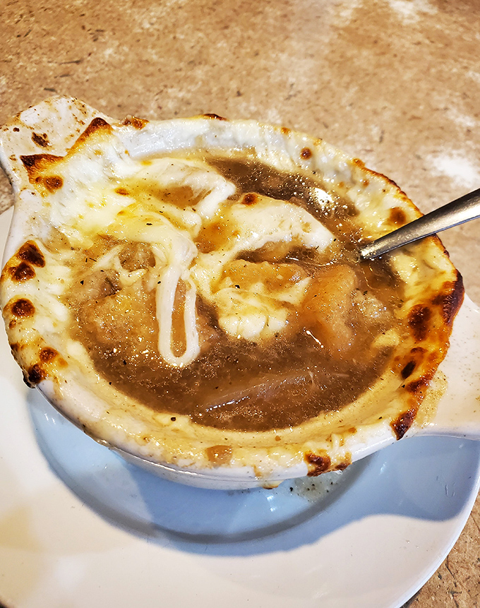 French onion soup that's having an identity crisis as a cheese delivery system. That broiled top is the crusty roof over a savory swimming pool.