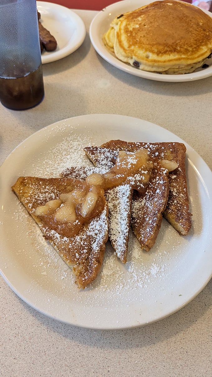 French toast that doesn't need a fancy Instagram filter—just powdered sugar, warm apple topping, and your undivided attention.