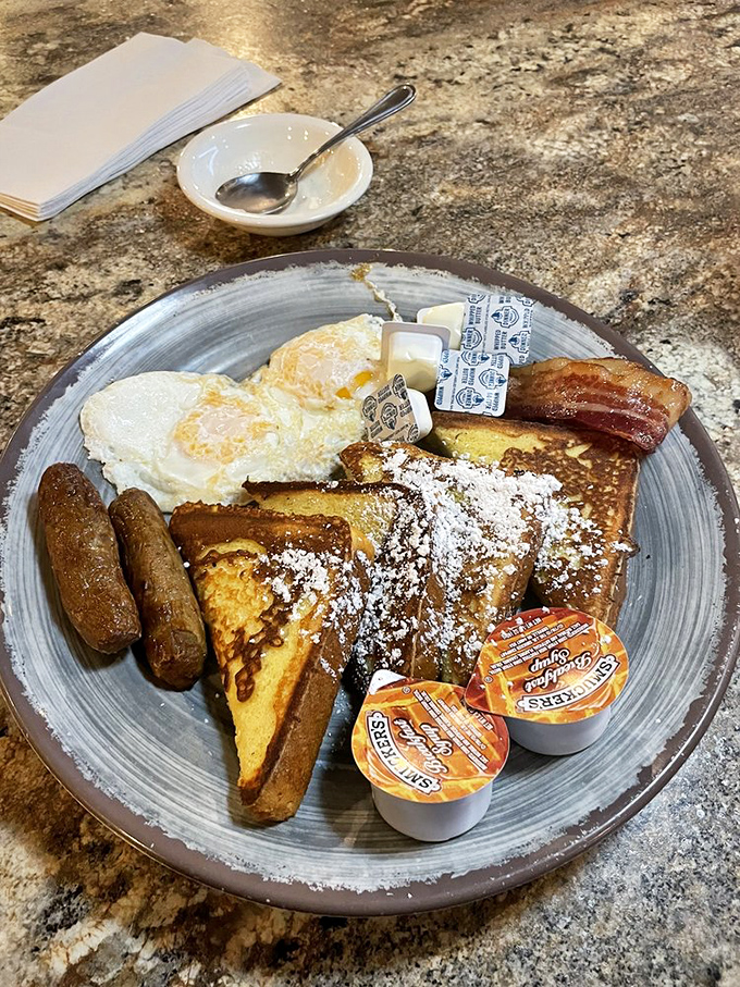 French toast that's achieved breakfast celebrity status, complete with powdered sugar snowfall and sausage sidekicks ready for their maple syrup bath.