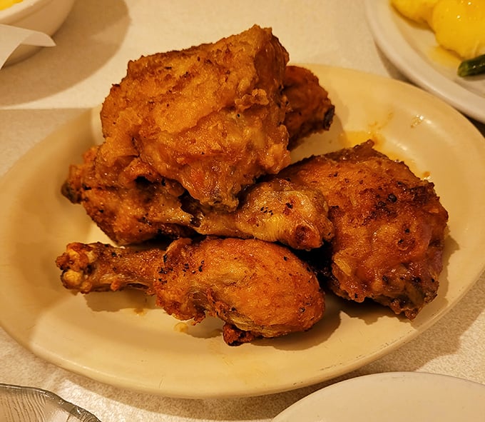 Fried chicken so perfectly golden it belongs in Fort Knox. The kind of crispy exterior that makes a satisfying sound when your fork breaks through to juicy paradise.