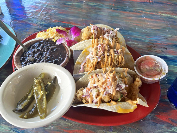 Taco Tuesday goes tropical! These fish tacos topped with zesty sauce and served with black beans and green beans offer a perfect Florida fusion experience.