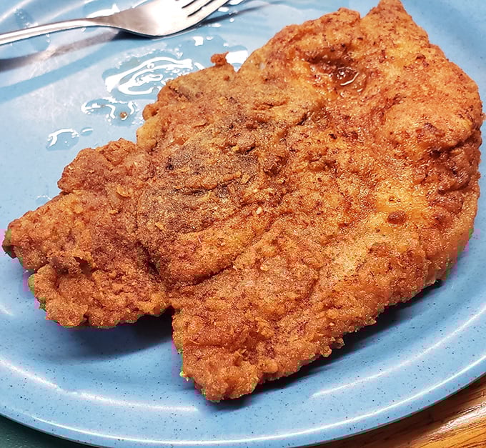 Golden-fried pork chops that crackle with each bite, resting on a blue plate that's seen thousands of happy diners. Simplicity at its most delicious.
