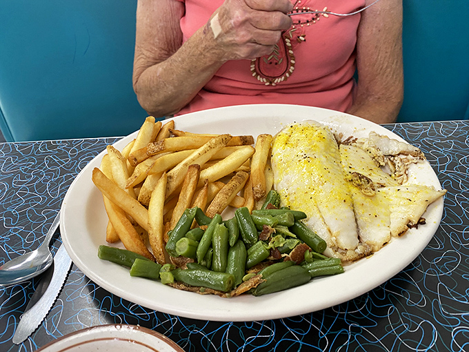 Golden fries, vibrant green beans, and perfectly cooked fish create a plate that's as visually appealing as it is delicious&mdash;comfort food elevated to an art form.