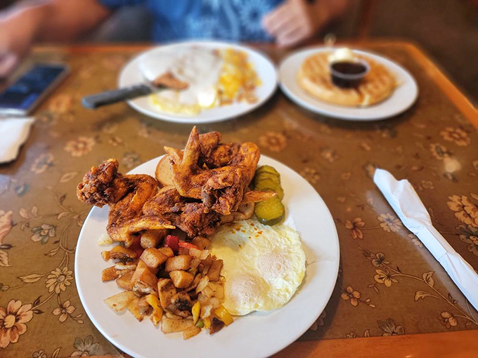 Breakfast of champions! Crispy fried chicken, eggs, and home fries create the holy trinity of morning indulgence. Those pickles add the perfect tang.