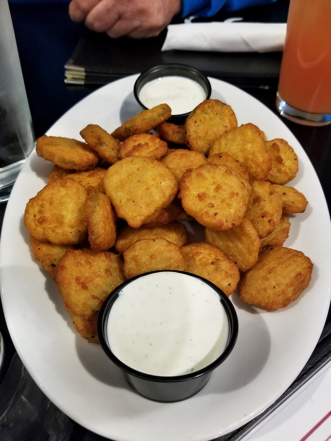Golden-fried pickle chips that crunch like your favorite childhood snack but taste like grown-up happiness. Two dipping sauces because decisions are hard.