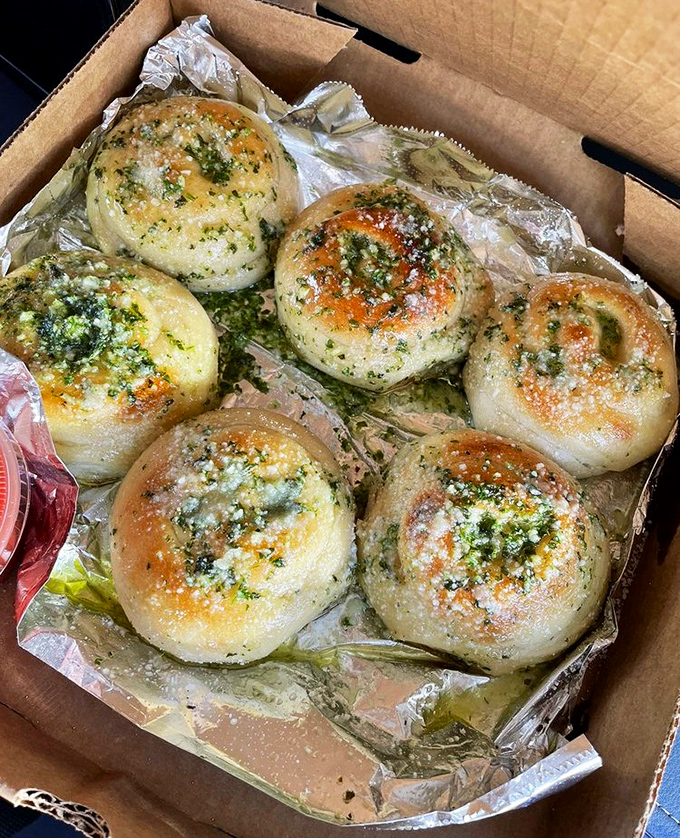 Garlic knots that could make a vampire reconsider their life choices. Golden, glistening bundles of joy that demand to be torn apart and savored.