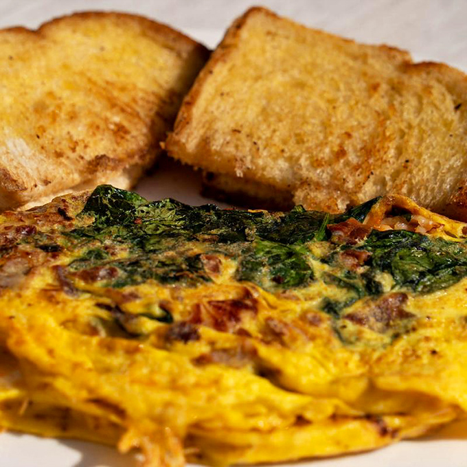 An omelet that doesn't just incorporate ingredients—it celebrates them. Paired with golden toast, it's the breakfast equivalent of a standing ovation.