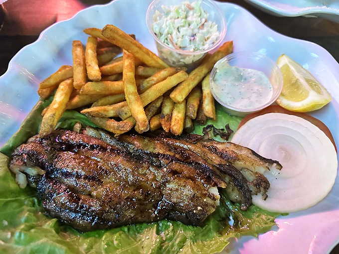 Blackened grouper that wears its grill marks like medals of honor, resting on a bed of lettuce that knows it's just along for the ride.