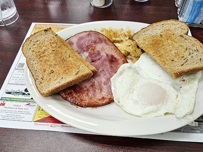 The breakfast trinity&mdash;perfectly fried eggs, thick-cut ham, and golden toast&mdash;simple perfection that makes morning people out of night owls.