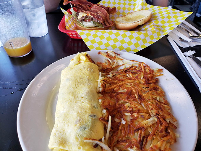 The omelet: a perfect yellow pillow stuffed with goodness, accompanied by hash browns that achieved the holy grail of crispy-outside-fluffy-inside.
