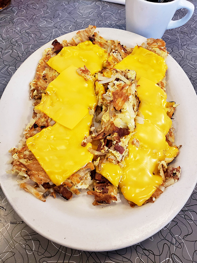 Loaded hash browns under a blanket of melted American cheese &ndash; breakfast engineering at its finest and most deliciously unapologetic.