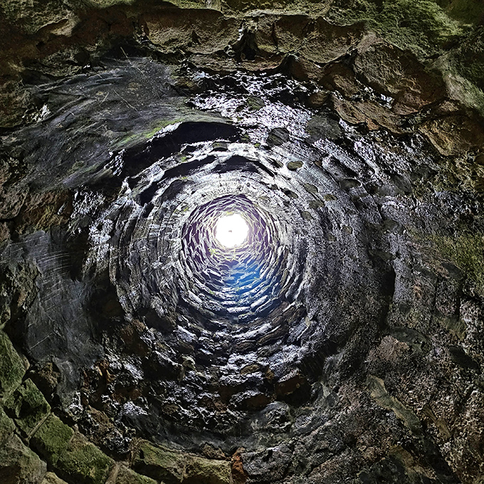 Looking up through Helen Furnace Park's stone chamber feels like peering through a portal to another dimension, where light and shadow play their eternal game.