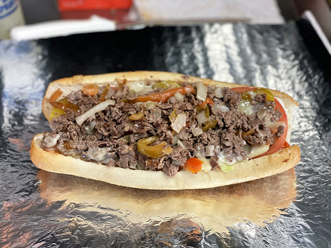 The classic Philly cheesesteak in its natural habitat: thinly sliced beef, perfectly grilled with onions and peppers, ready for devouring.