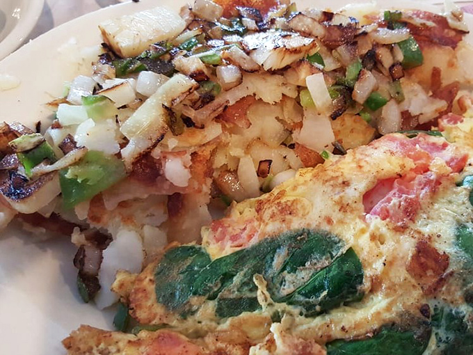 An omelet that's clearly been to finishing school, perfectly paired with home fries that have achieved that mythical crispy-outside, fluffy-inside perfection.