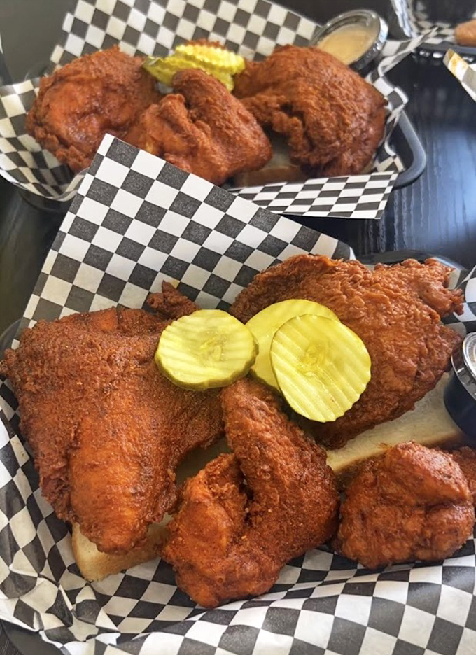 Fried chicken perfection doesn't need fancy plating&mdash;just checkered paper, pickle chips, and that glorious reddish crust promising flavor that'll haunt your dreams.