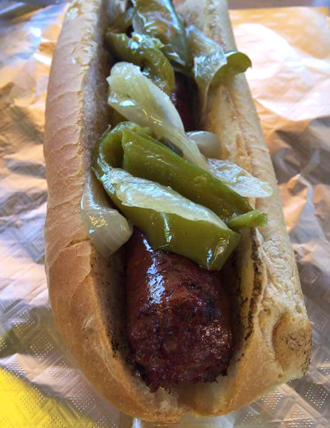 A sausage adorned with the proper accessories. Sometimes the simplest pleasures—like peppers and onions—make the perfect companions.