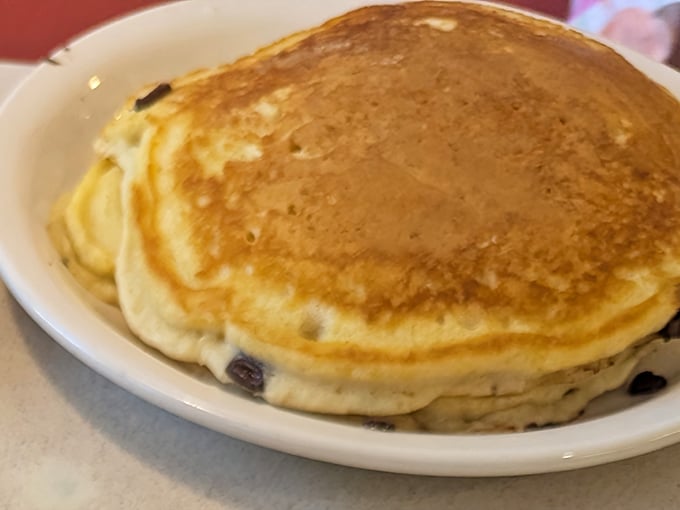 Golden, fluffy hot cakes that have absorbed decades of breakfast wisdom. The blueberries aren't just fruit&mdash;they're little bursts of morning joy.