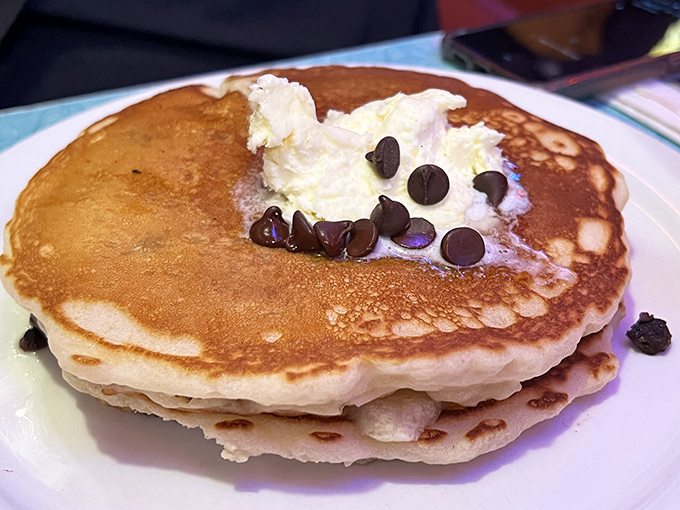 Fluffy hotcakes adorned with chocolate chips and whipped cream—breakfast that boldly crosses the border into dessert territory without apology.