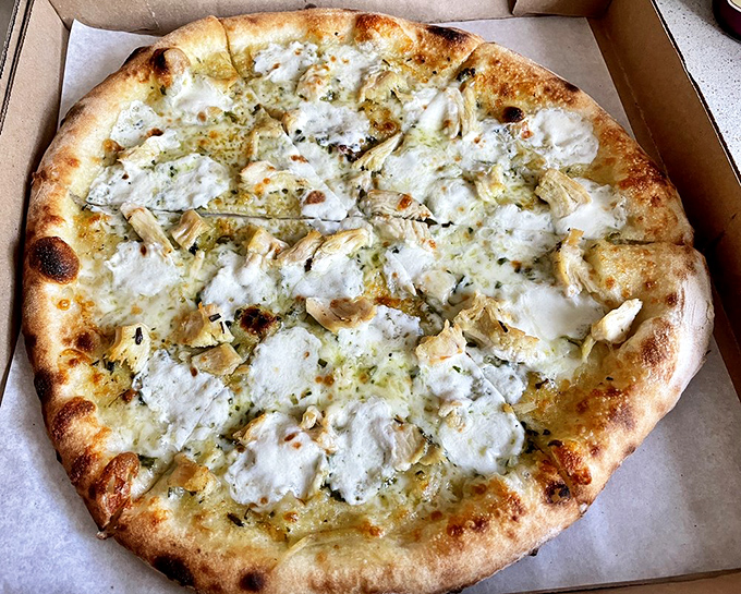 This white pizza doesn't miss the red sauce one bit. Chicken and pesto dancing together in perfect harmony on that blistered crust.