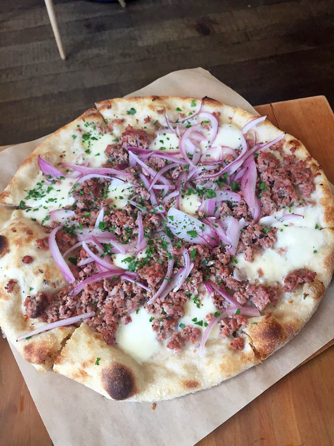 This sausage pizza with red onions isn't just food—it's a flavor symphony where each ingredient gets its solo moment before the perfect finale.
