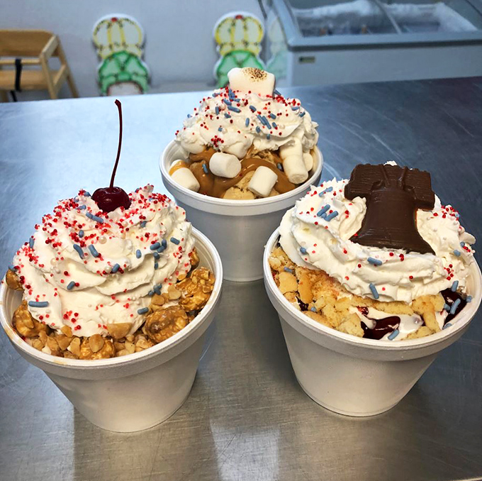 Three patriotic sundaes standing at attention, proving that sometimes the most American thing you can do is enjoy excessive amounts of whipped cream.