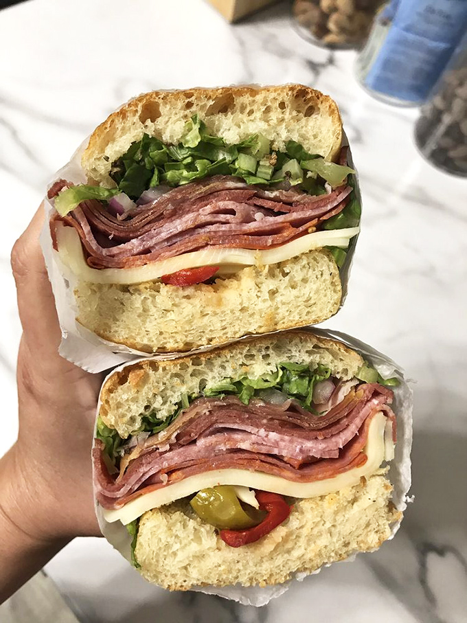 This Italian isn't just a sandwich, it's architecture – layers of cured meats, cheese, and veggies creating the structural integrity only Italian grandmothers truly understand.