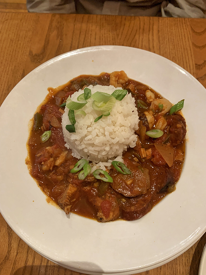 A mountain of rice surrounded by a savory sea of jambalaya. The green onions aren't just garnish&mdash;they're the perfect finishing touch.
