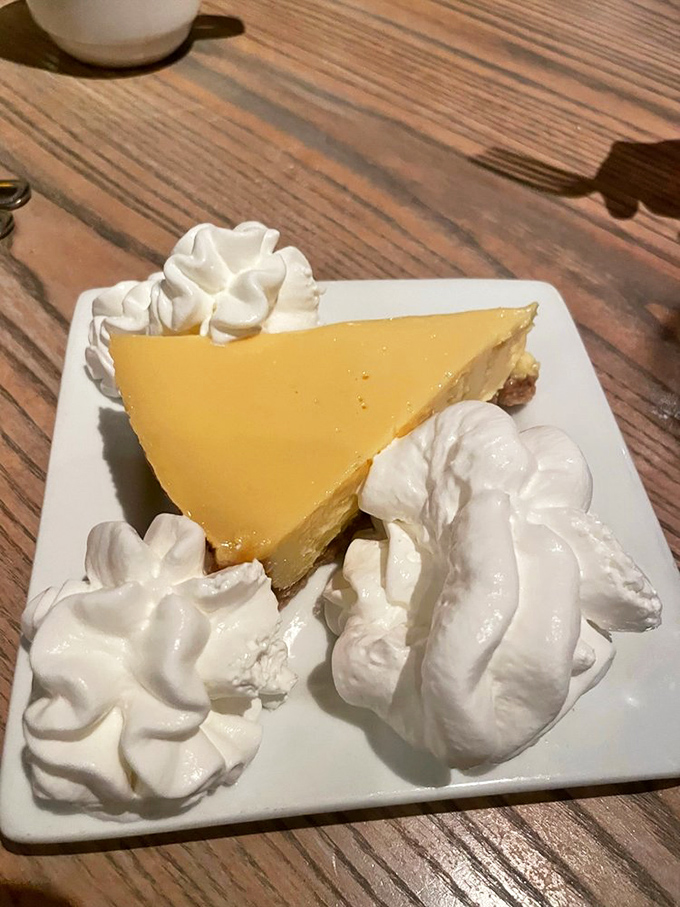 Key lime pie that strikes the perfect balance between tart and sweet, surrounded by clouds of whipped cream like a citrus sun setting into meringue mountains.