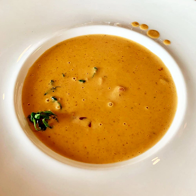 The lobster bisque arrives like a liquid sunset, velvety and rich. Each spoonful is a warm embrace from the Atlantic. Soup that's worth getting dressed up for.