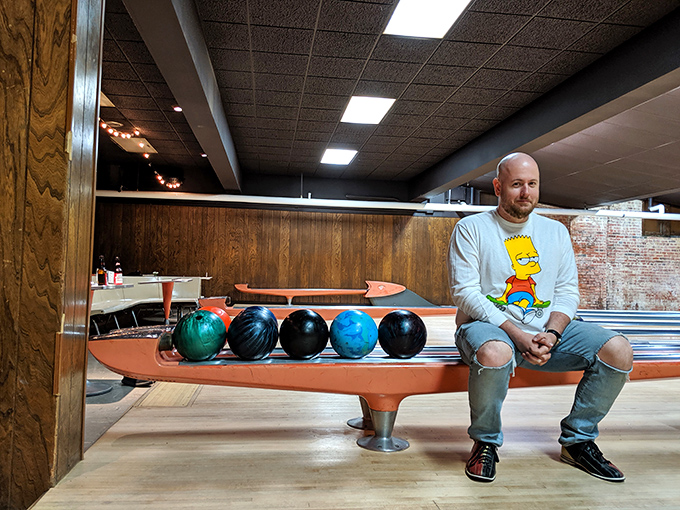 The ball return bench—that sacred spot where bowlers contemplate their next move while colorful spheres wait their turn to knock down pins.